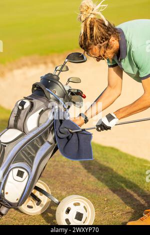 male golfer choosing a club from his bag Stock Photo - Alamy