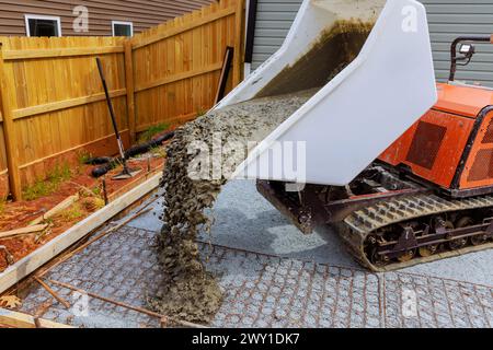 Wet cement is poured into framework during foundation construction ...