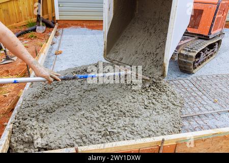 Concrete buggy truck is used to pour wet cement into framework during ...