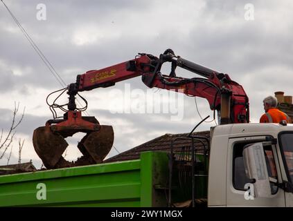 Rubble grab lorry removing stone and soil with a clamshell bucket on a ...