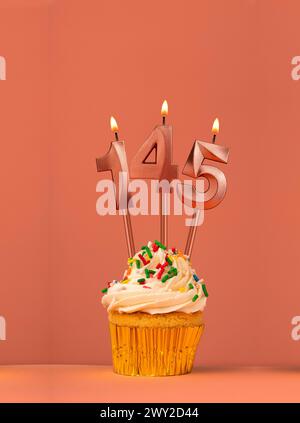 Birthday cupcake with number 145 candle - Sparkling orange background ...