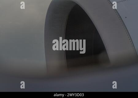 Closeup of cowling of jet engine with cloud cover in background. Taken ...
