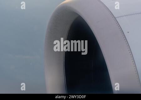 Closeup of cowling of jet engine with cloud cover in background. Taken ...