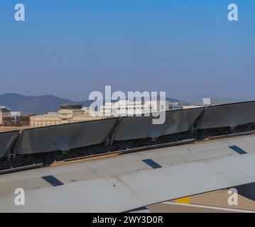 Aircraft wing with breaking flaps extended during landing with airport ...