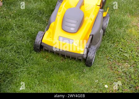 Yellow lawn mower on the spring green grass in the yard Stock Photo - Alamy