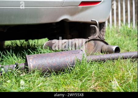 Broken exhaust and muffler of a car, rusted silencer fallen down on the ...