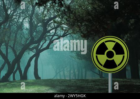 Radioactive pollution. Yellow warning sign with hazard symbol in rural ...