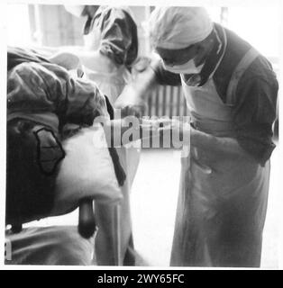 A patient with a leg badly damaged by shrapnel receives anesthetic ...