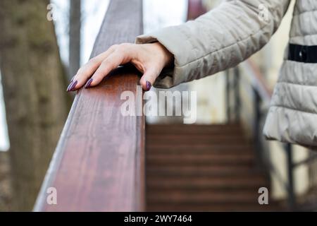 woman holding on to the railing going down the stairs. hand holding the ...