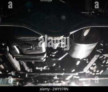 Auto-mechanic examining underbody of car, checking condition of engine ...