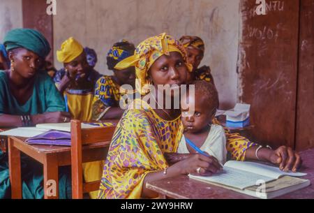 Senegal, Djogo, mother and child during a lesson of an adult education ...