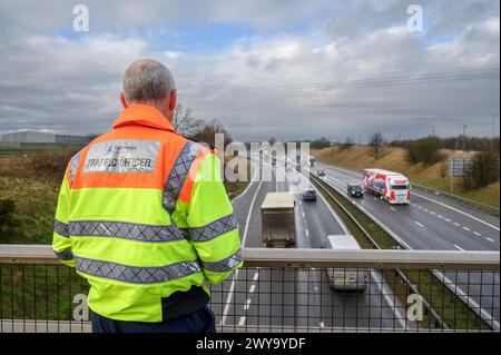 Highways England traffic officer observing traffic flow from a bridge ...