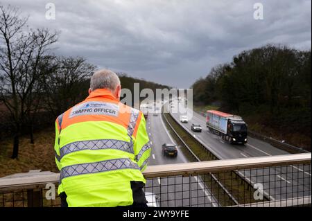 Highways England traffic officer observing traffic flow from a bridge ...