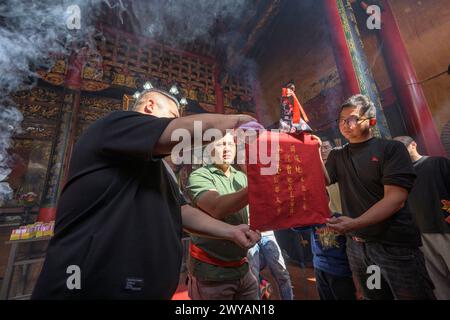 Temple ritual with individuals holding a red ritual banner Stock Photo ...