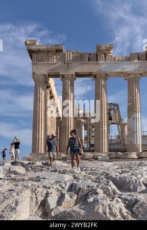 Tourists walk around the Parthenon at the ruins of the Acropolis in ...