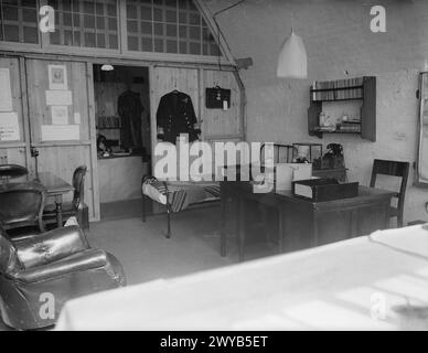 In 1941, an office interior at Dover Naval Base is depicted, showing ...