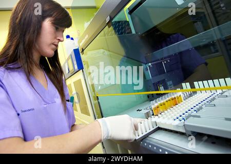 Lab technician loading blood samples for coagulation test analysis in ...