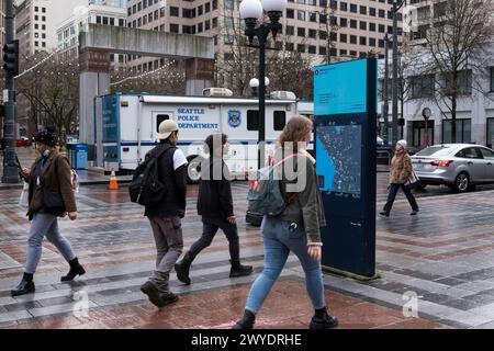 Seattle, USA. 10th Mar, 2024. People passing a tourist map and mobile ...