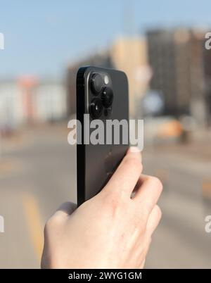 A young woman captures video using a smartphone stabilizer in a sunny ...