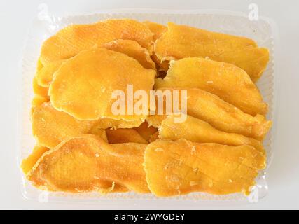 Dry mango in plastic container on a light background Stock Photo - Alamy