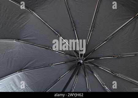 The inside of black umbrella with spokes Stock Photo - Alamy