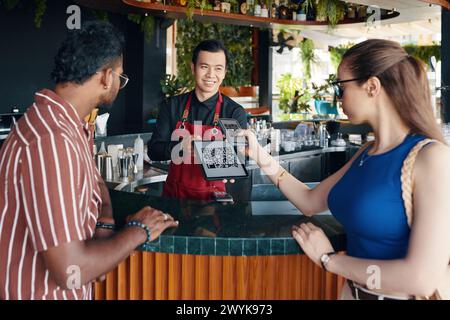 Woman use smartphone to scan QR code for order menu in cafe restaurant ...