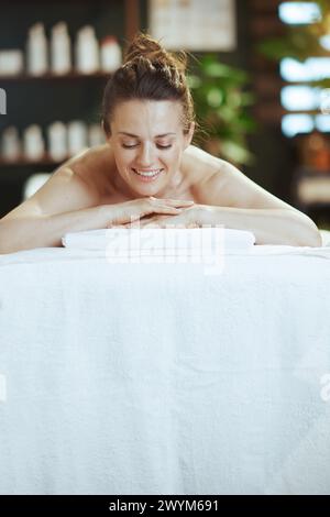 Healthcare time. massage therapist in massage cabinet massaging clients belly on massage table ...