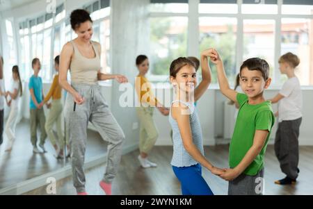 Preteen children learn to dance tango under guidance of a teacher in ...