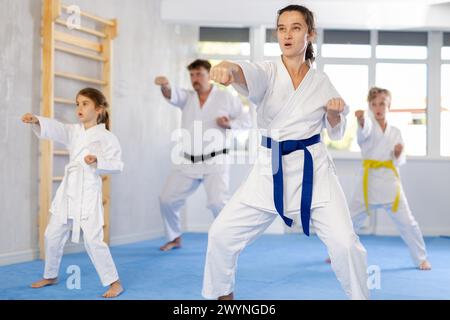 Woman practicing kata routine during family training at karate class ...