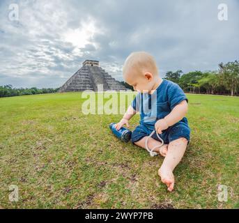 Baby traveler, tourists observing the old pyramid and temple of the ...
