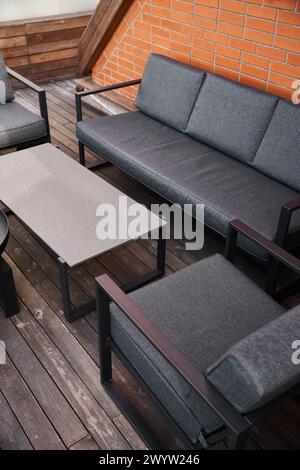 Comfortable chairs placed on wooden terrace near wall of residential ...