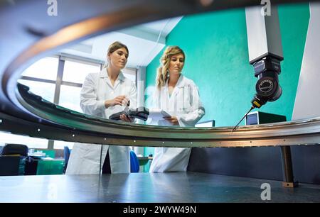 Technicians inspecting aircraft component. Measurement of a piece in ...