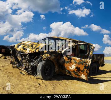 A damaged military armored vehicle, a passenger car , a jeep and ...