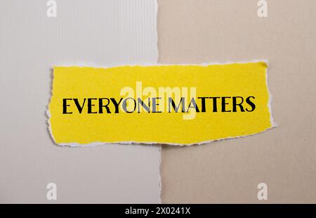 Everyone matters words written on ripped white paper pieces with red ...