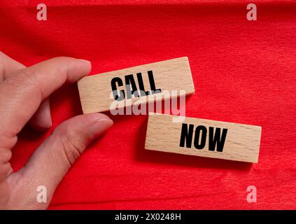 Call now words written on ripped yellow paper with blue background ...