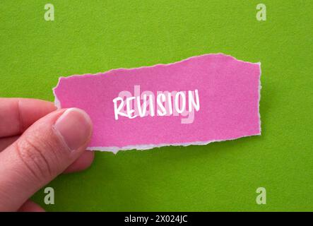 Revision word written on ripped yellow paper with blue background ...