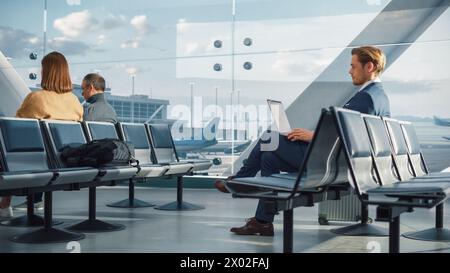 Airport Terminal: Businessman Uses Laptop Computer, Waiting for His ...