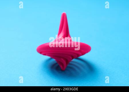 One pink spinning top on light blue background, closeup Stock Photo - Alamy