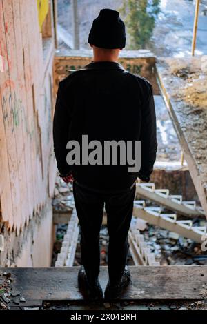 Man stands in an abandoned building. wandering men. man in a protective ...
