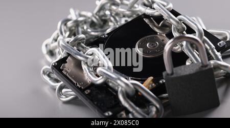 Hard drive is wrapped in chain and secured with padlock. Cybersecurity ...