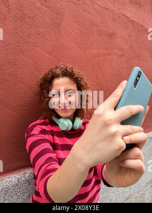 Redhead woman wearing striped shirt and glasses standing over isolated ...
