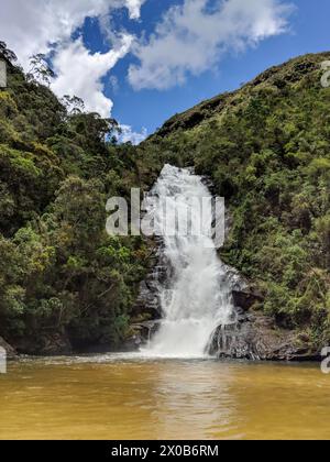 Beautiful stream flowing amidst mountains at Seljavellir against cloudy ...