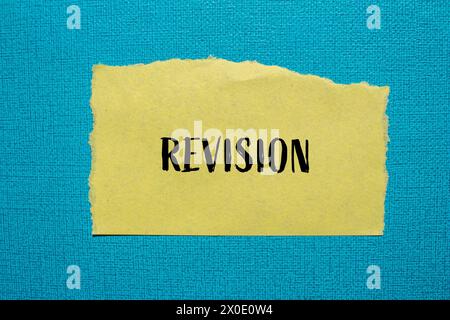 Revision word written on ripped blue paper piece with brown background ...