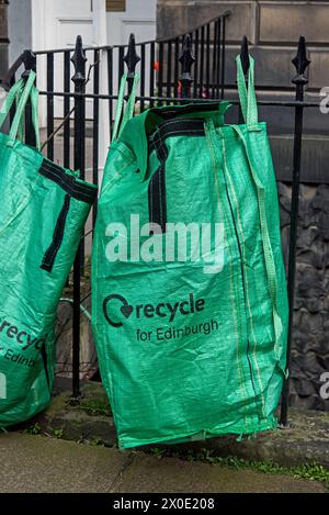 Green gull-proof recycling sacks attached to railing and awaiting ...