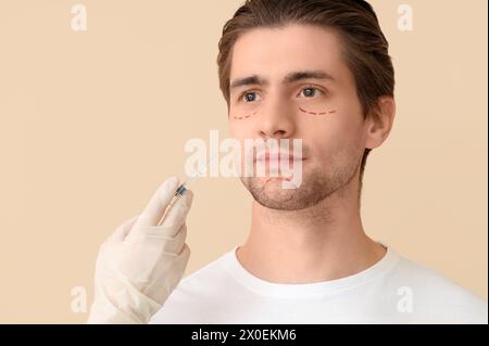 Young man with marked face receiving injection on light background ...