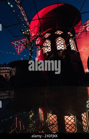 Moulin Rouge at night with lights during French sunset. Spinning moulin ...