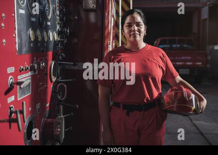 Female firefighter holding machinery while standing on field against ...