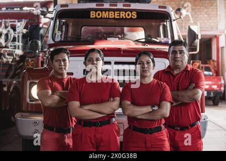 Portrait of confident firefighters at fire station against clear sky ...