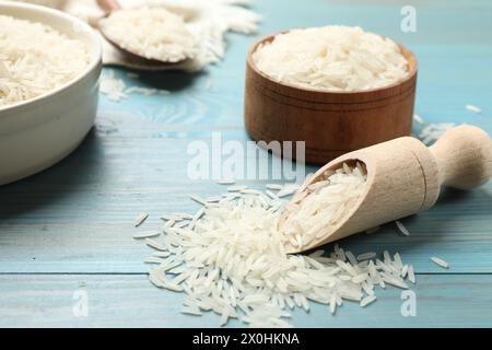 Rice groats scattered on a light wooden background closeup. Shallow ...