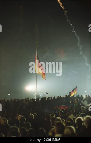 A crowd celebrates German reunification in front of the Reichstag ...